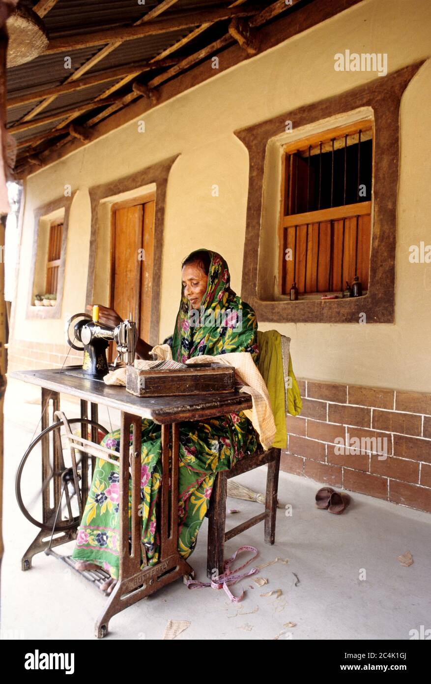 A woman works with sewing machine. Readymade Garments Industry (RMG ...
