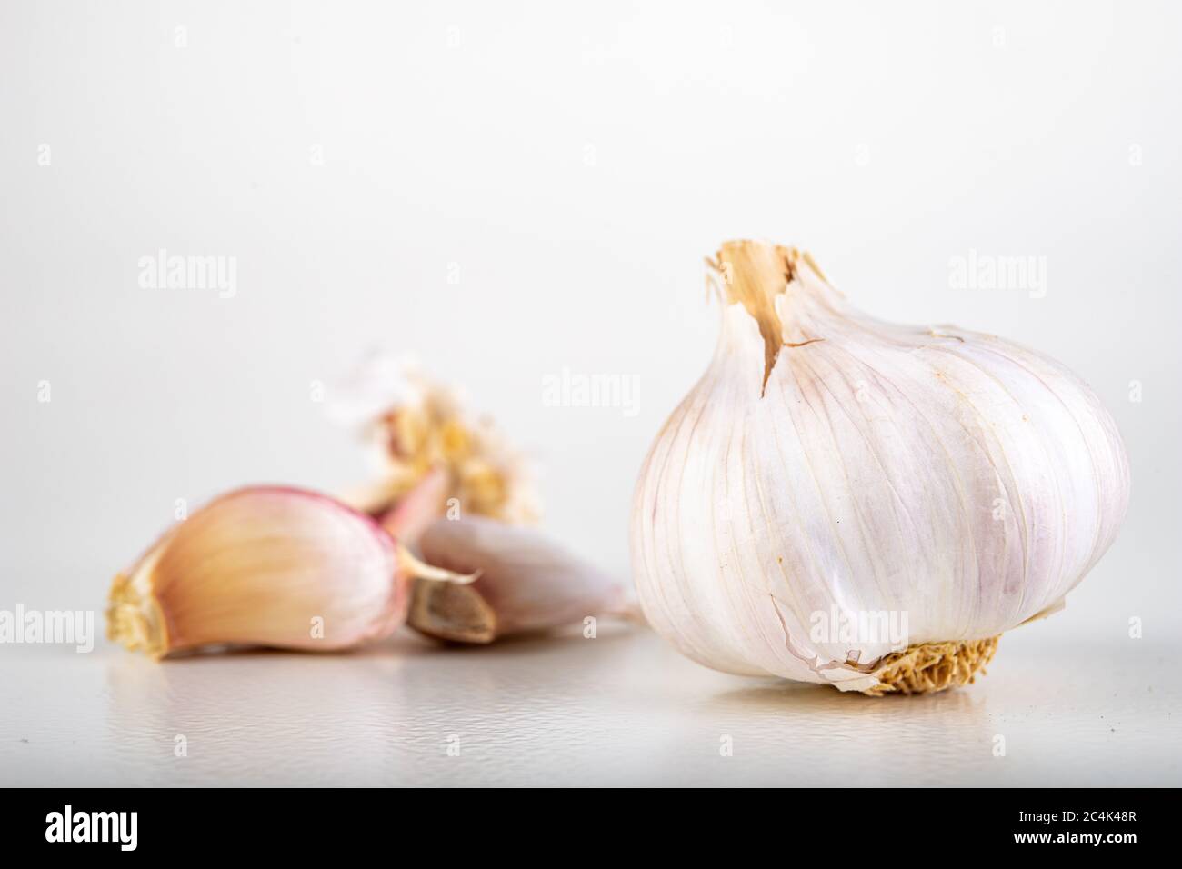 A whole head of garlic and a few cloves of garlic. Vegetables used in ...