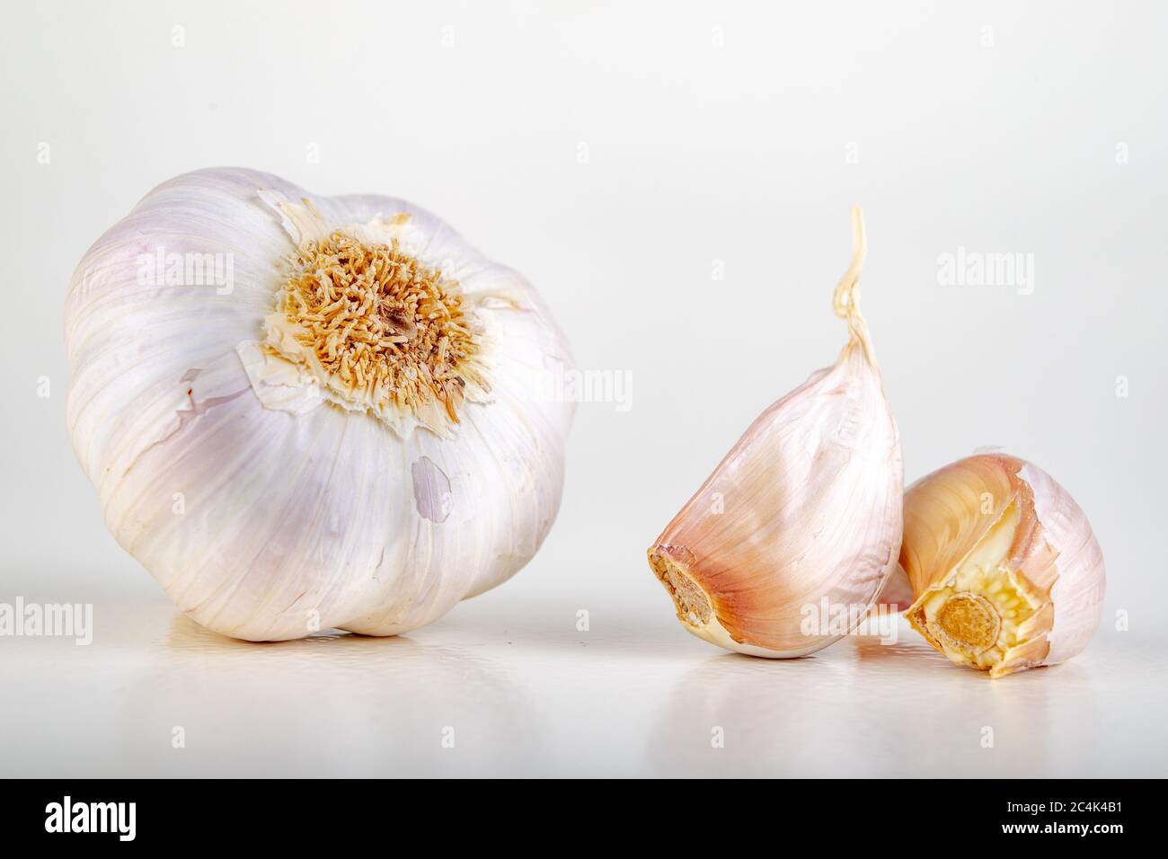 A whole head of garlic and a few cloves of garlic. Vegetables used in ...