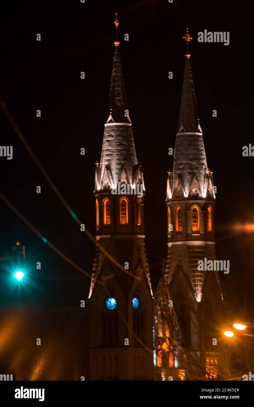 View of church towers. Illuminated towers of a neogothic church. Night ...