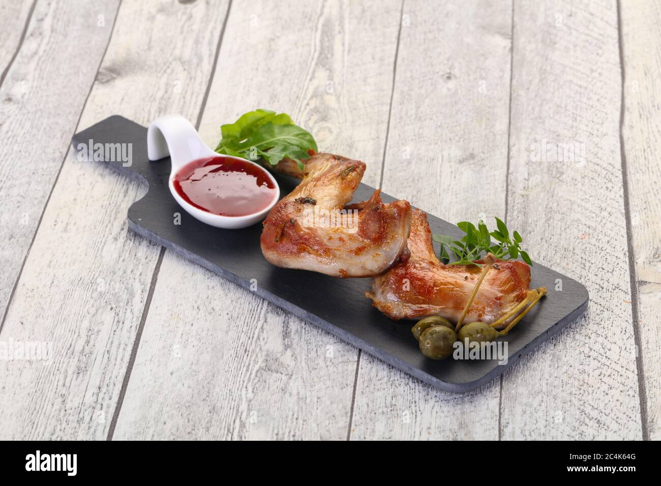 Roasted rabbit legs with cowberry sauce Stock Photo - Alamy