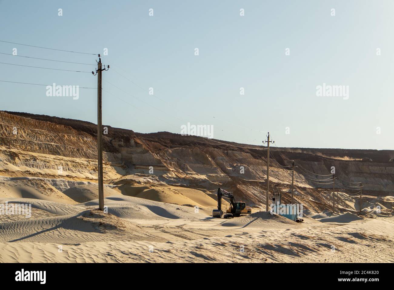 Yellow excavator working digging in sand quarry Stock Photo - Alamy