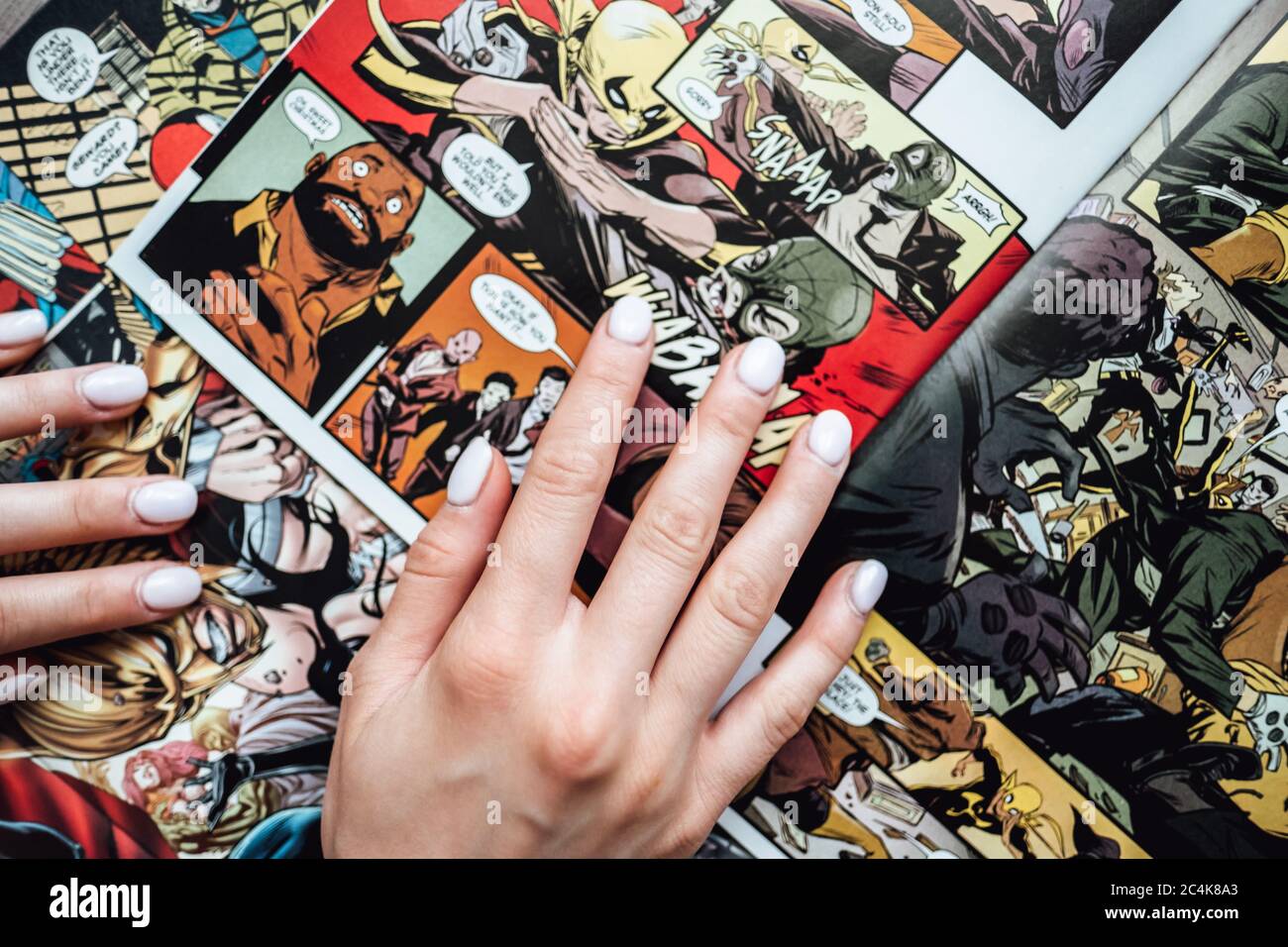 Hand flipping through comic book pages Stock Photo - Alamy