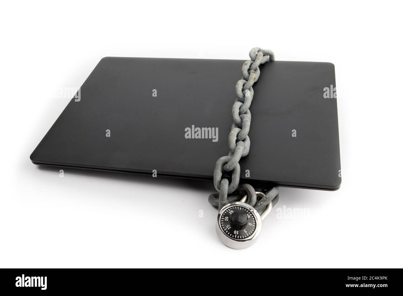 a closed notebook computer with a chain and combination lock wrapped ...