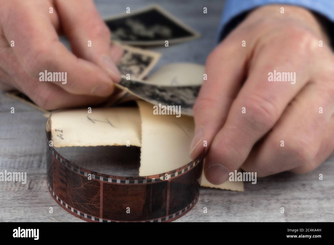 an elderly man holding old black and white photographs in his rough ...