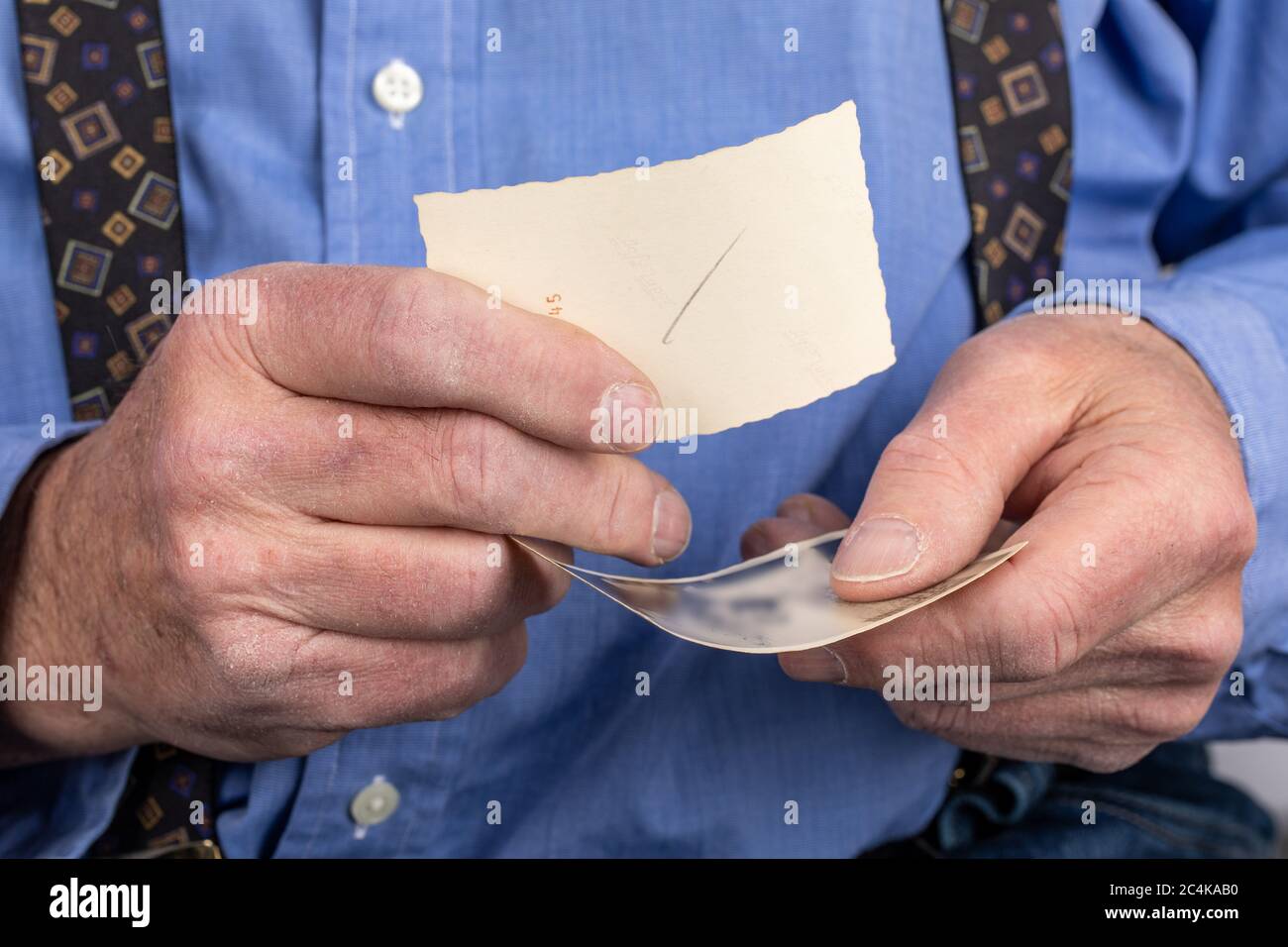an elderly man holding old black and white photographs in his rough ...