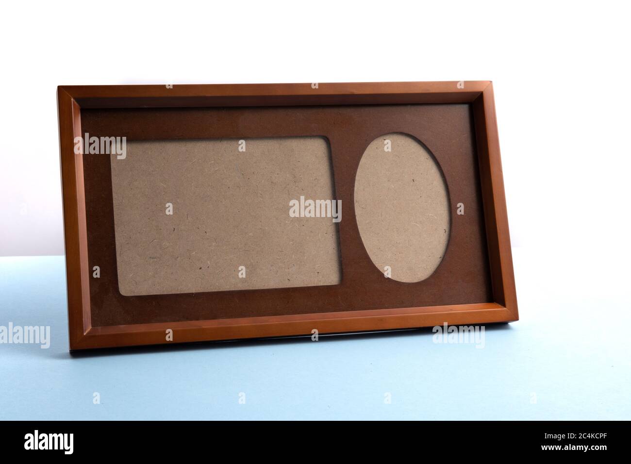 an empty wooden photo frame and mat on a blue table Stock Photo - Alamy