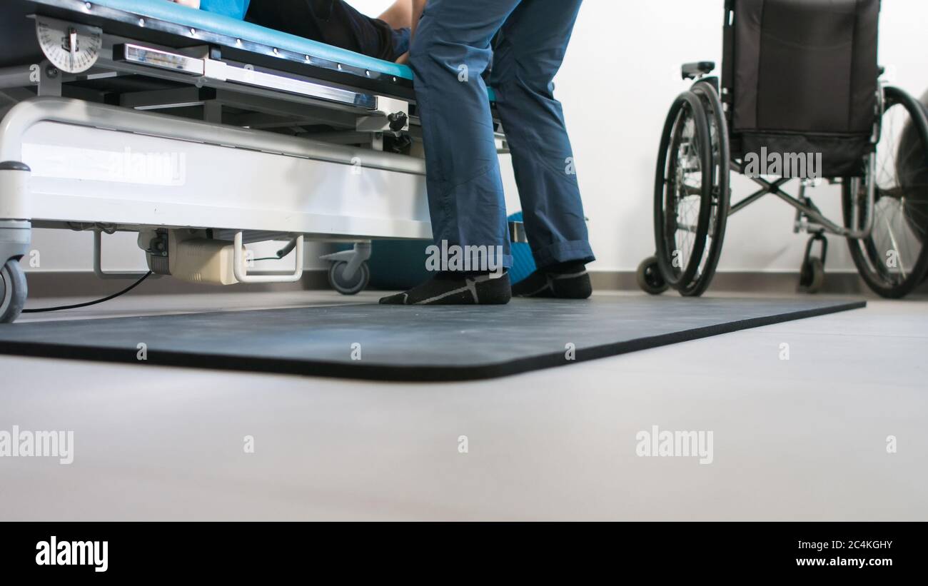 Physiotherapist exercising with disabled person using wheelchair on a ...