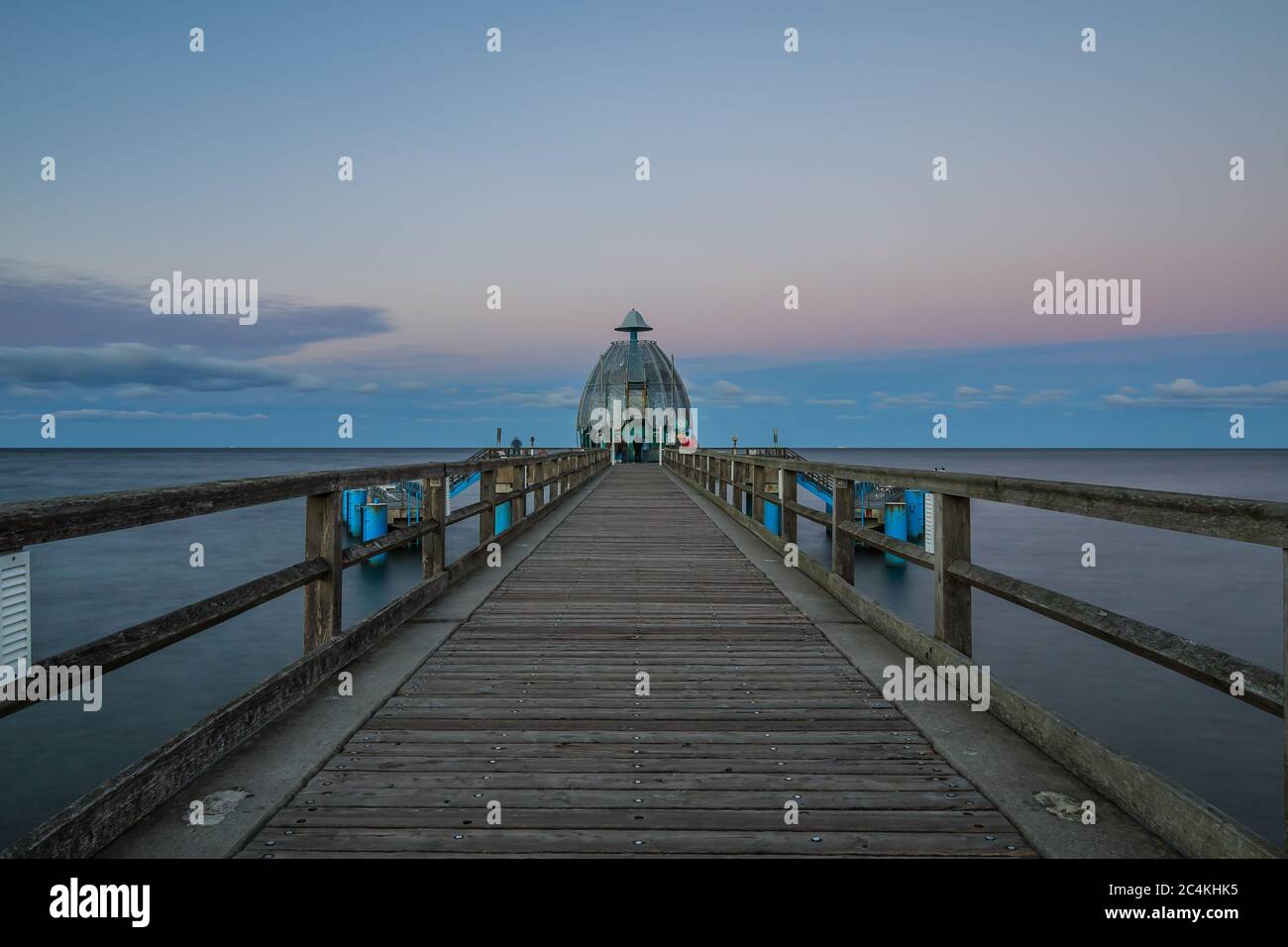 Wooden walkway with railings along the coastline and diving bell at the ...
