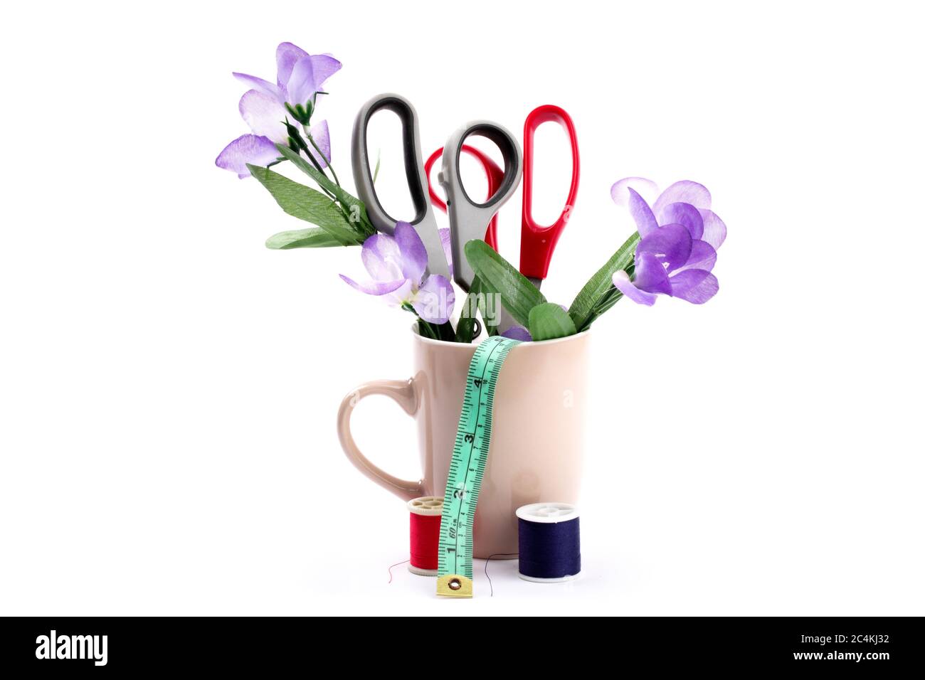 tailor's or dressmaker's scissors and a tape measure in a coffee cup ...