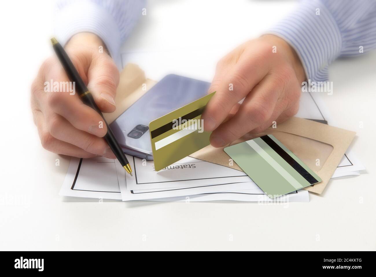 a man with several credit cards checks his statement with a pen on a ...