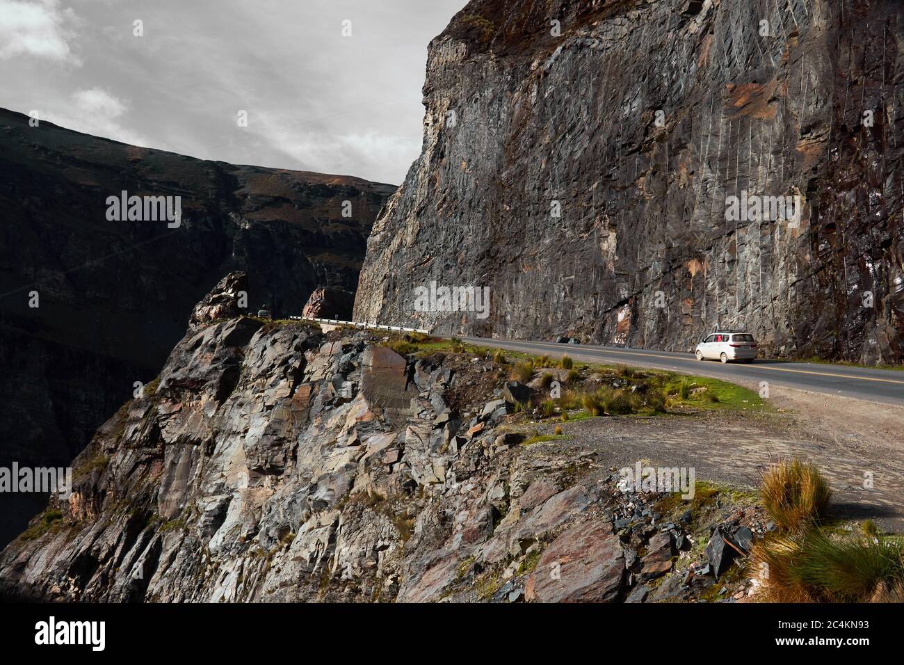 Picture of a white car on a road next to the huge cliff Stock Photo - Alamy