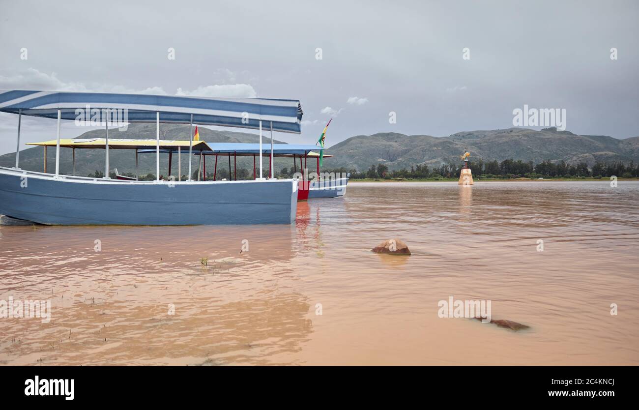 Horizontal shot of blue pontoon boats on a brown colored lake during ...