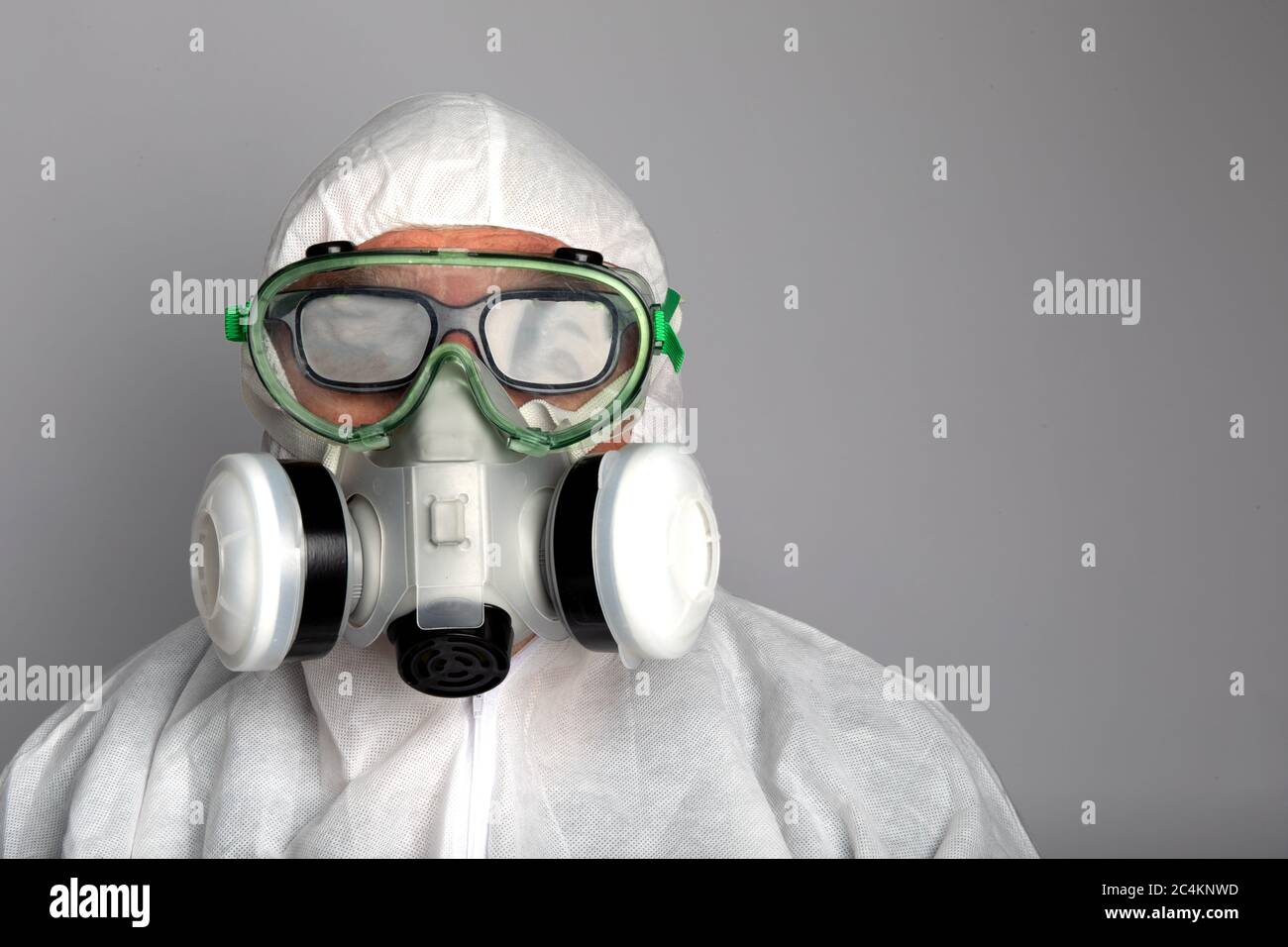 a person in a haz mat suit wearing an industrial dust and chemical mask ...