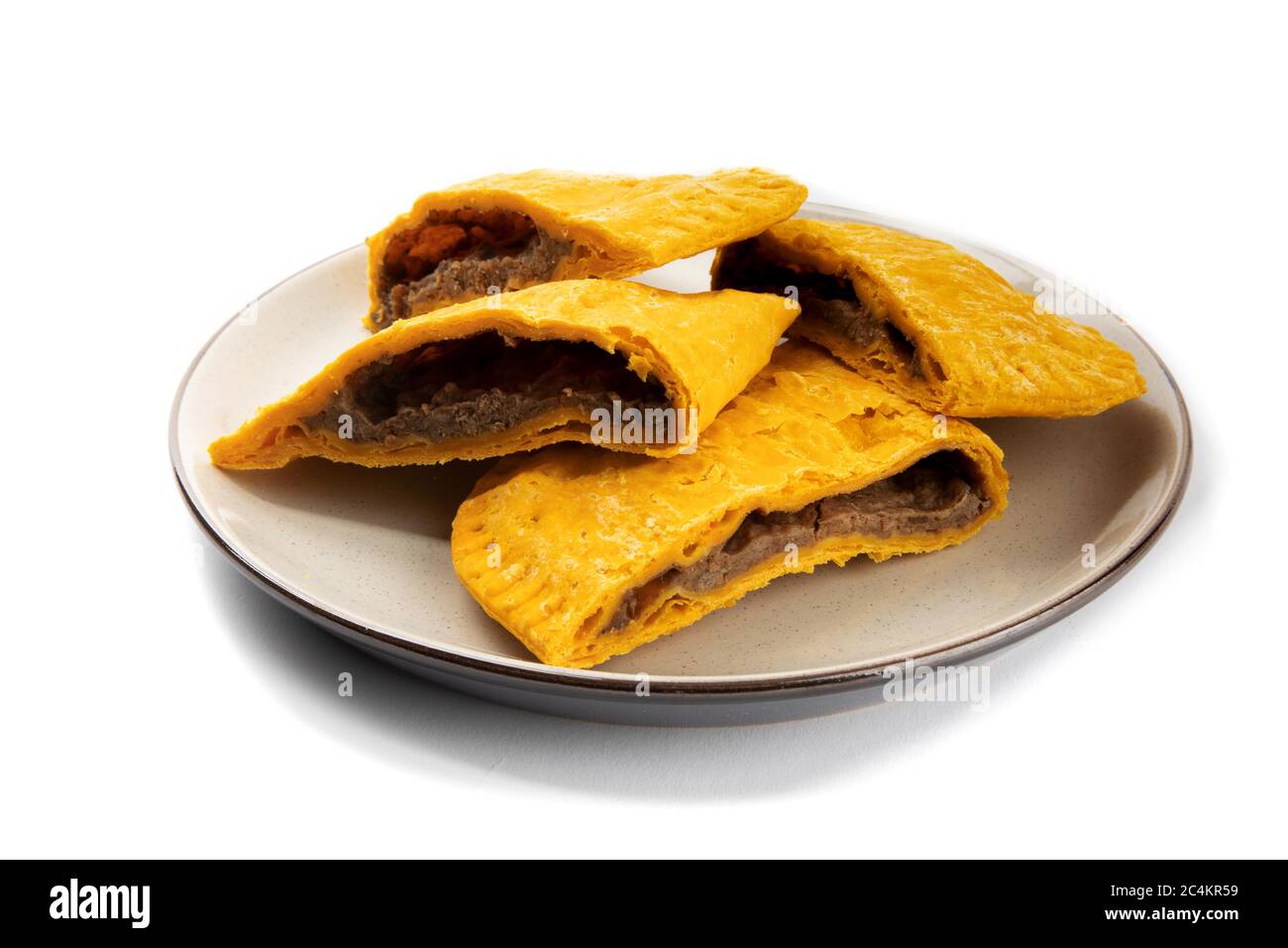 cut up spicy Jamaican or West Indies ground meat patties on a plate ...