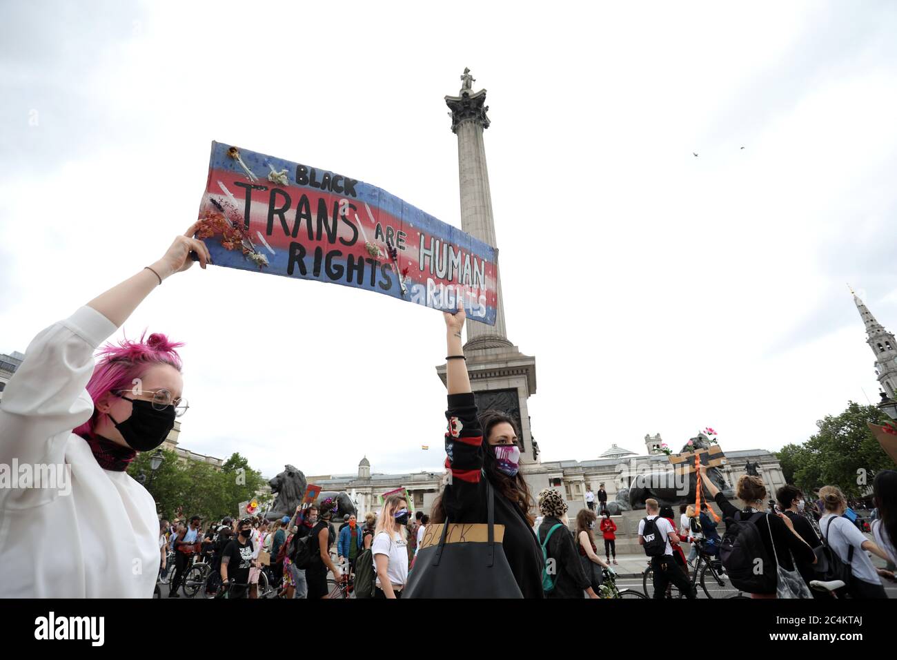London, UK. 27th June, 2020. People hold up a 'black trans rights are ...