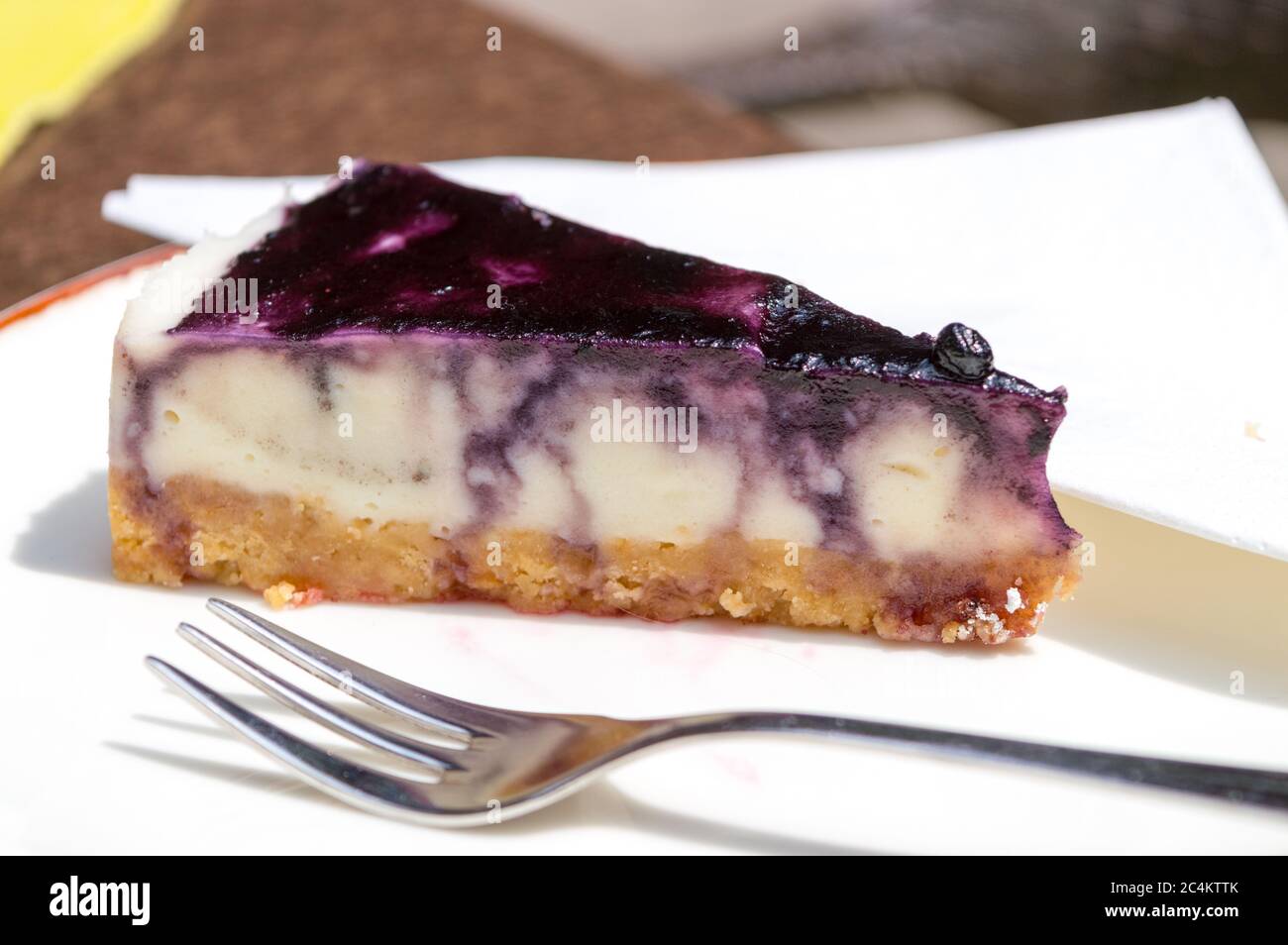 Blueberry cheesecake with blurred background, fork in the foreground ...
