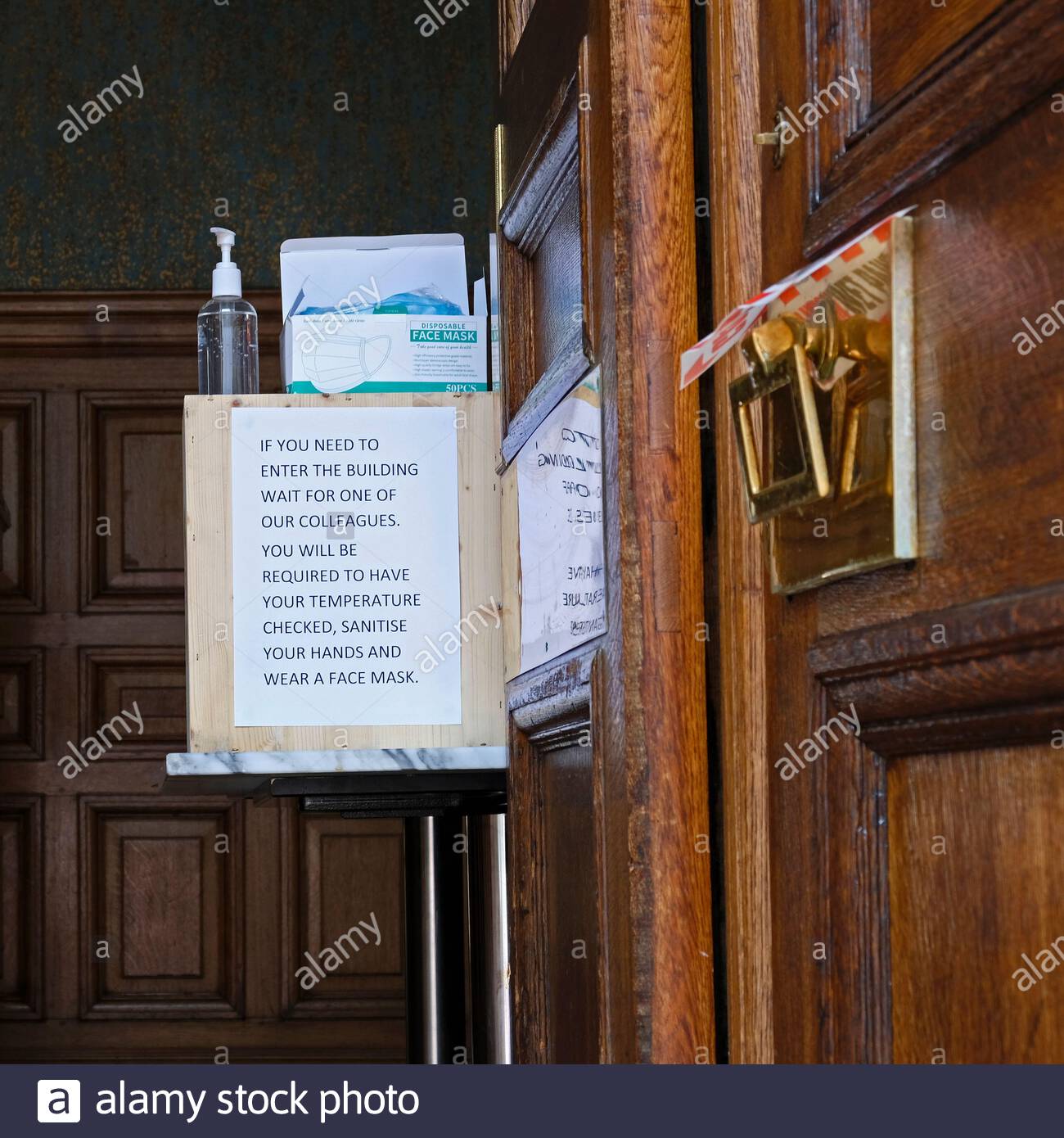 Building entrance with notice regarding lockdown measures and ...