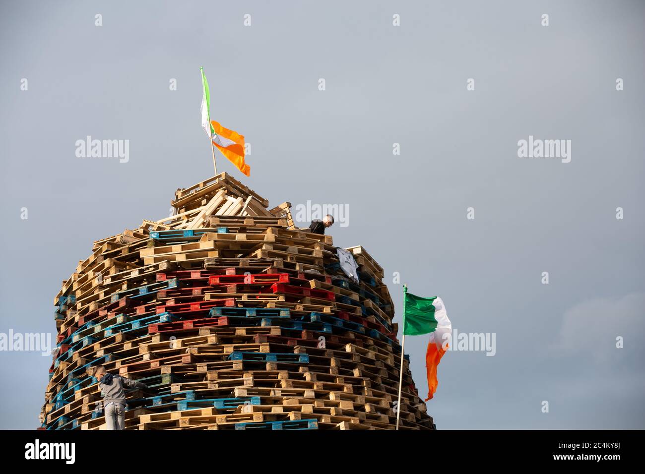 Fixing an Irish Tricolour flag on the top of a bonfire in the ...