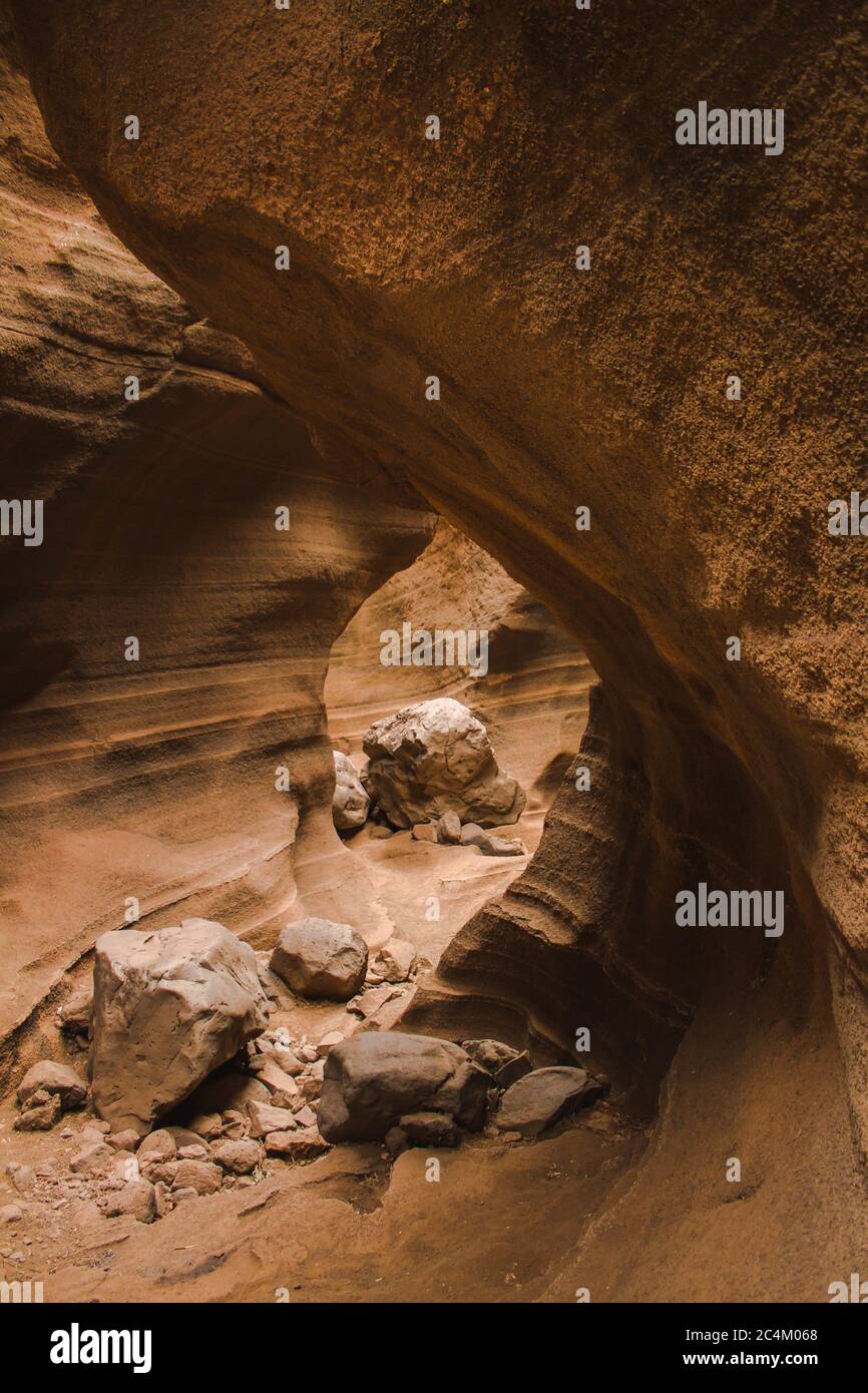 Vertical shot of a cave surrounded by brown rocks Stock Photo - Alamy