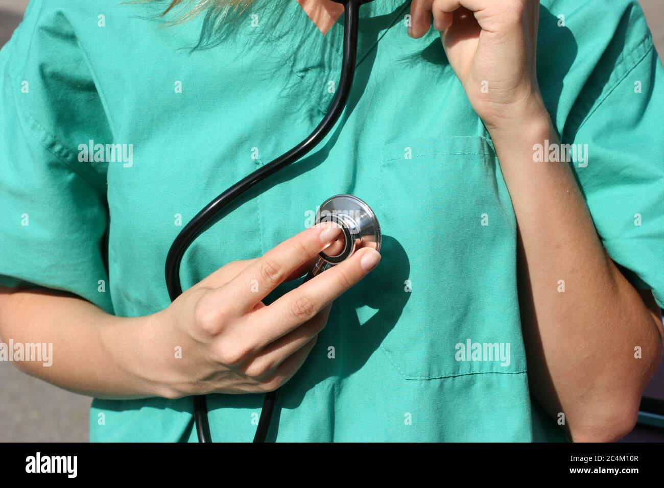 Medical nurse on checkup with stethoscope. & green scrubs Stock Photo ...