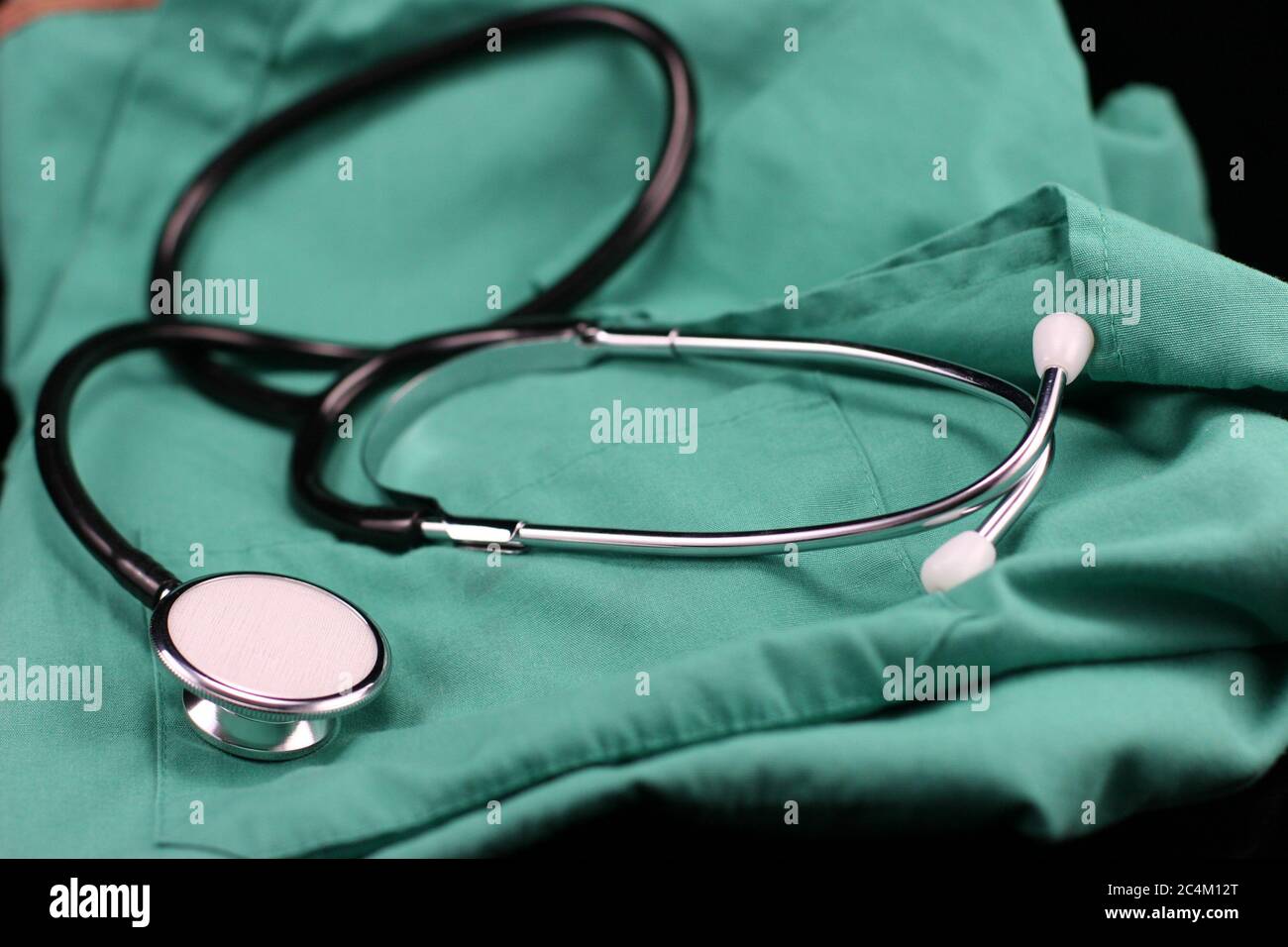 Checkup with stethoscope. with folded green scrubs Stock Photo - Alamy