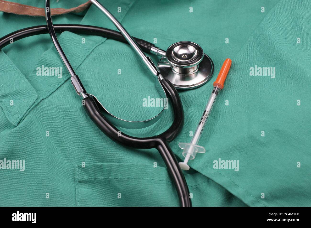 Medical stethoscope. with injection needle on top of nurse's green ...
