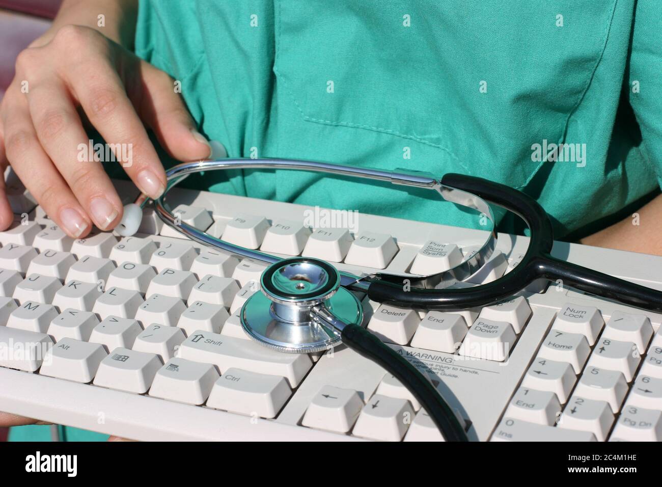 Medical nurse wearing green frock with hand & fingers on computer ...