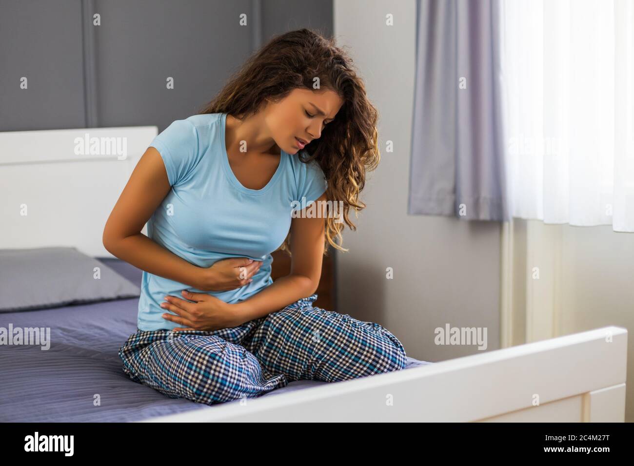 Sad woman having pain in stomach Stock Photo - Alamy
