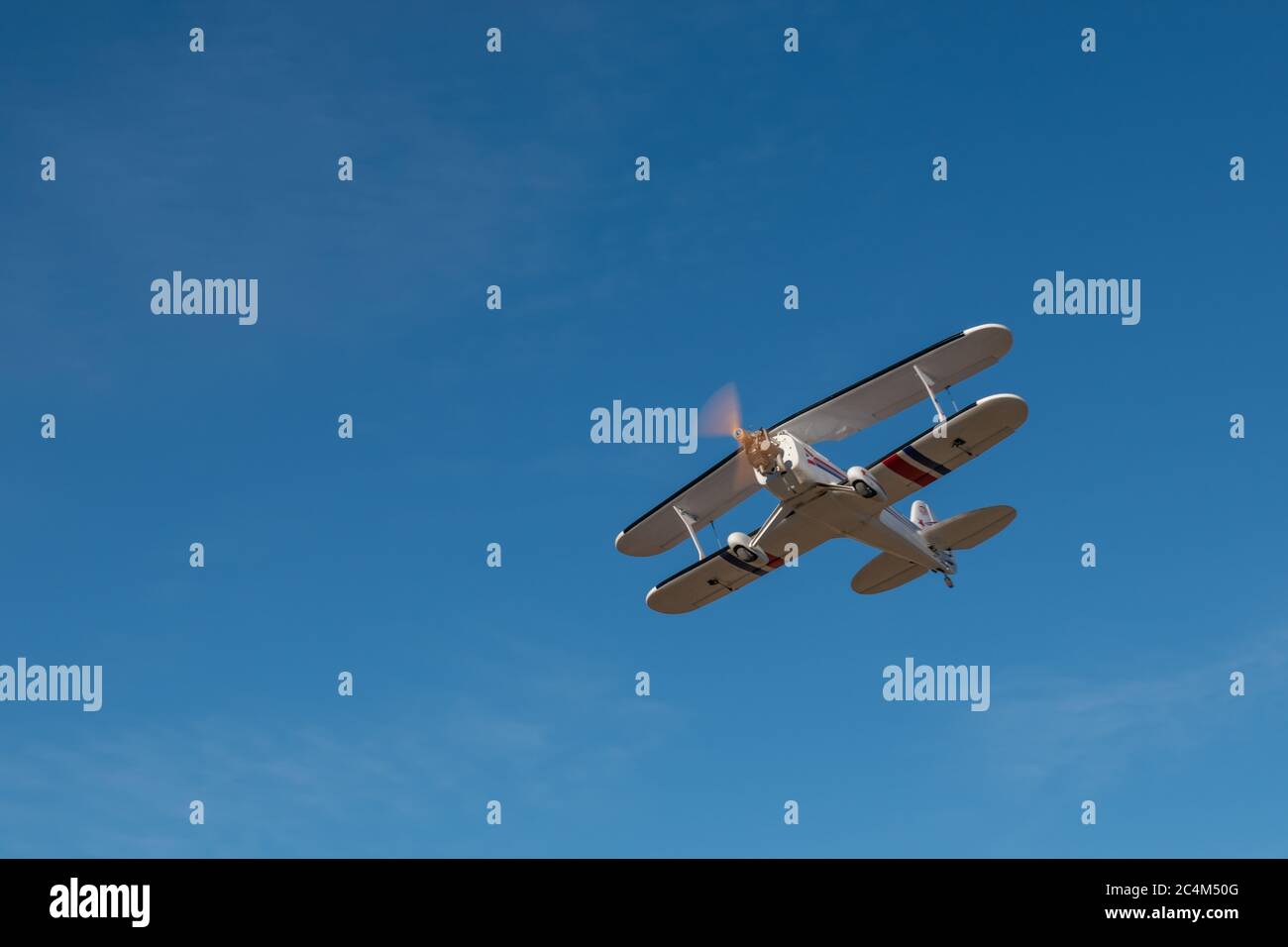 Low angle shot of an old white airplane flying in the clear blue sky ...