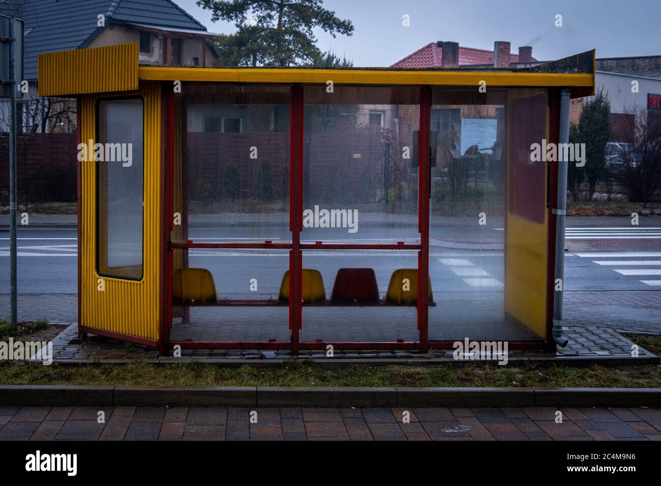 Yellow and red bus stop on the sidewalk in an urban area with a missing ...