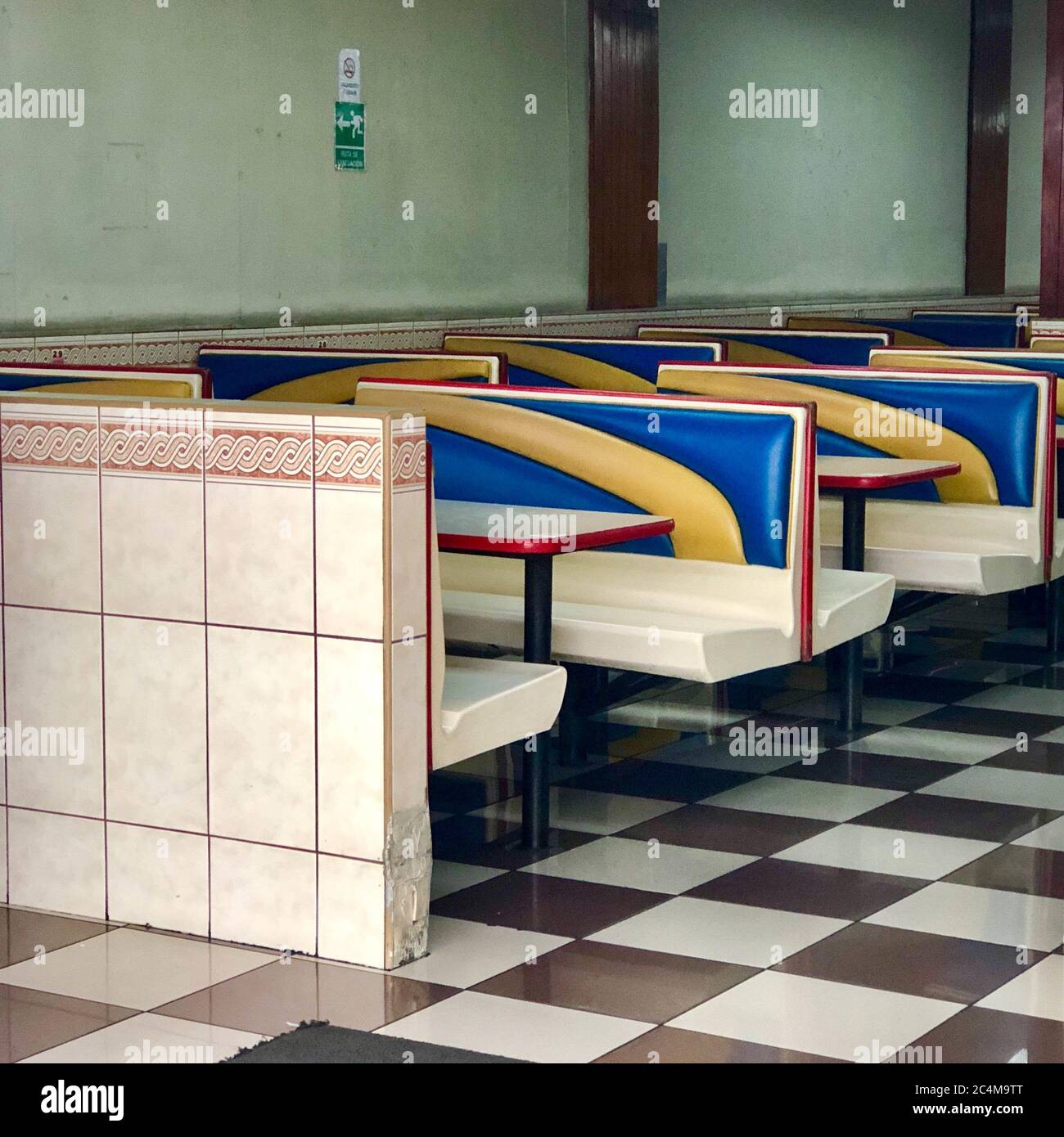 Empty diner area with white blue and yellow seats and brown and white ...
