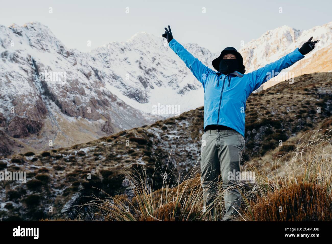 Man trekking in mountains. Cold weather, snow on hills. Winter hiking ...