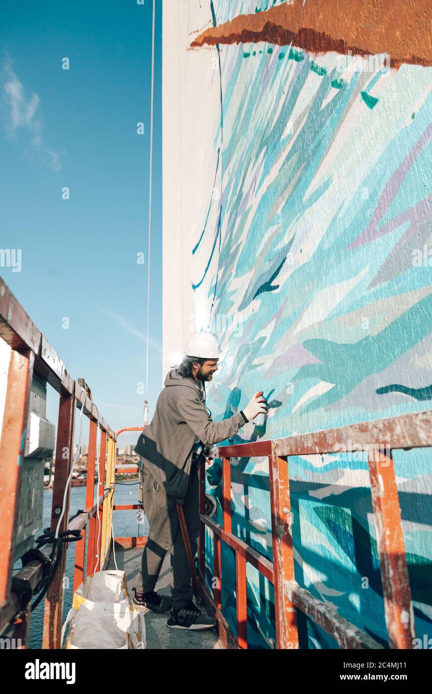 Male professional painter builder paints the wall of a new building at ...