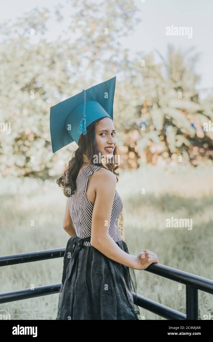 Portrait of a Filipino Woman wearing her Graduation cap, gown and Sash ...