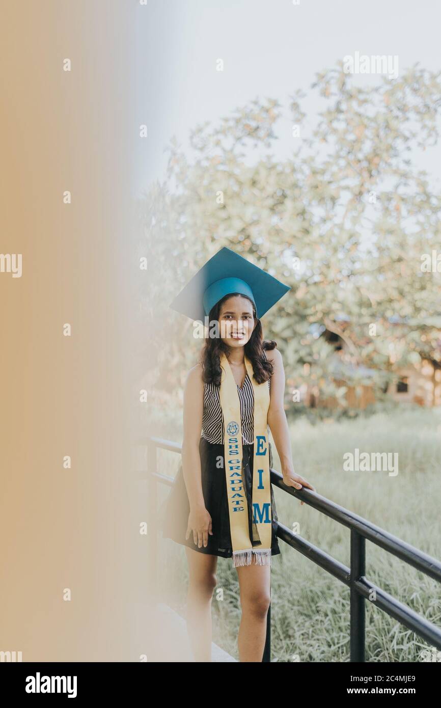 Portrait of a Filipino Woman wearing her Graduation cap, gown and Sash ...