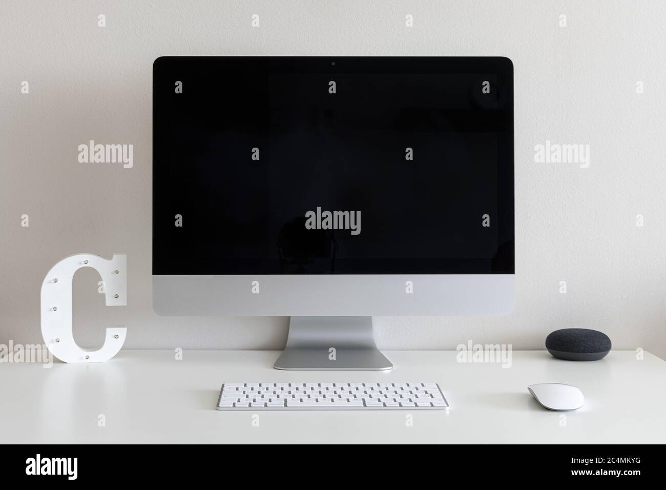 Work desk with a computer and the letter C against a white wall Stock ...