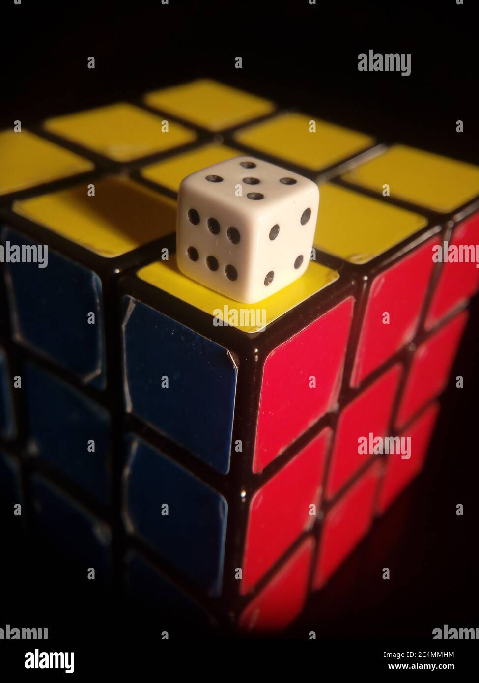 Vertical shot of Rubik's cube and white dice on top isolated on a black background Stock Photo ...