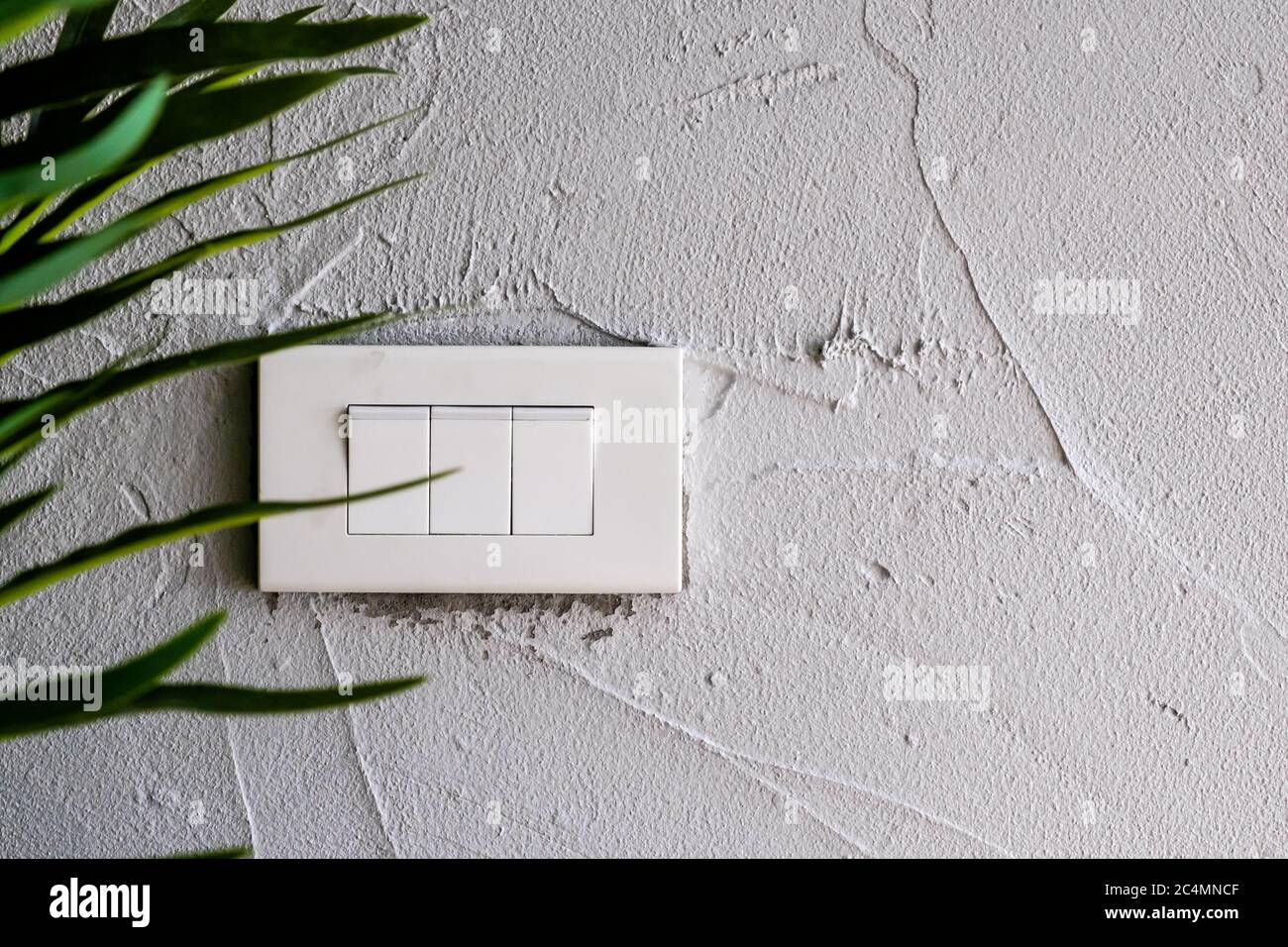 An isolated clear white light switch on the white grunge texture wall ...