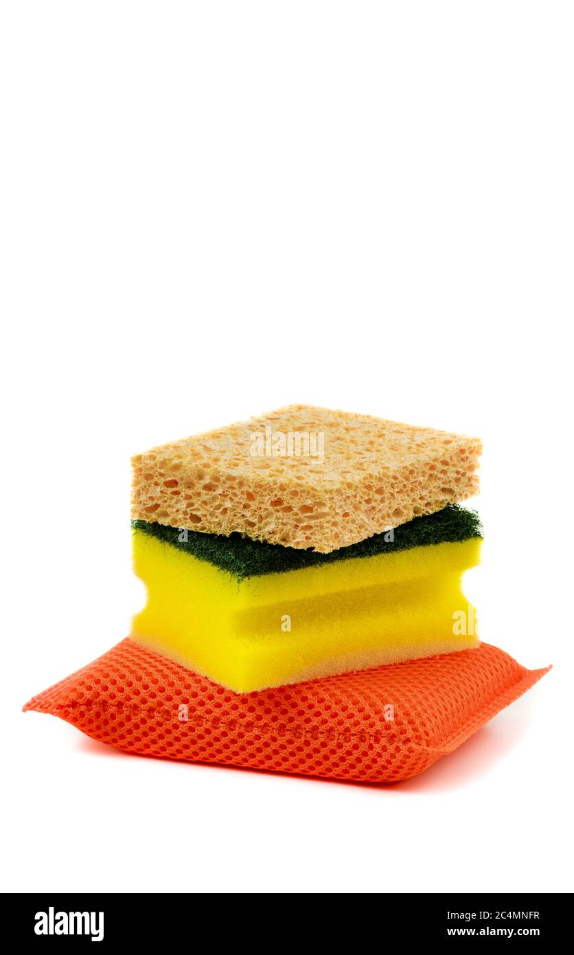 Vertical shot of yellow and orange sponges on an isolated white ...