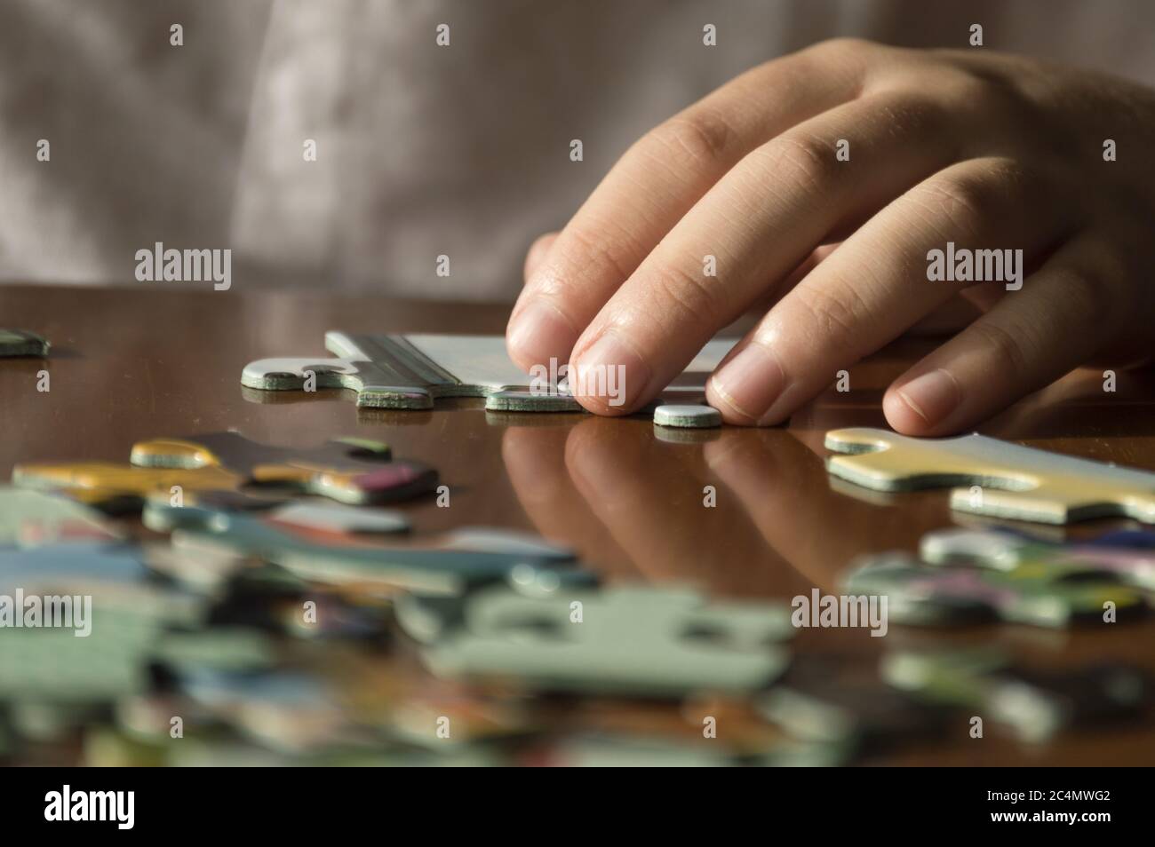 Closeup shot of a child's hands making a puzzle at home Stock Photo - Alamy