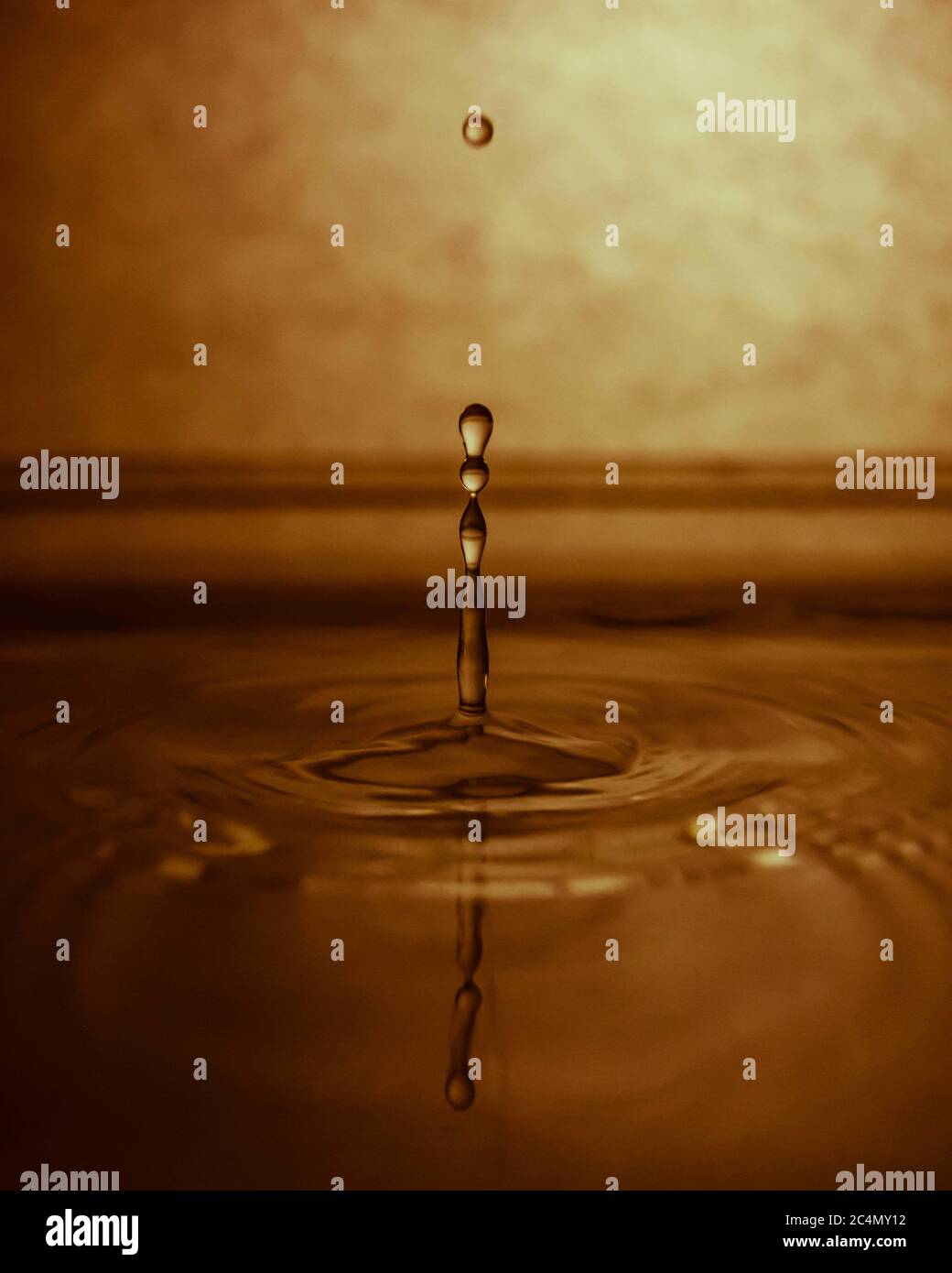 Water dripping and splashing with a yellow effect Stock Photo - Alamy