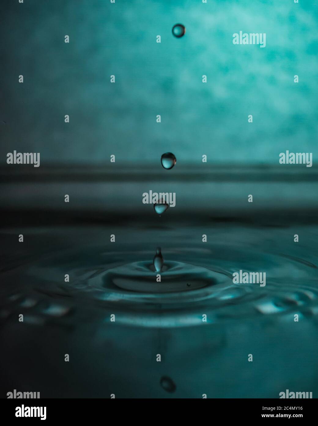 Water dripping and splashing with a blue effect Stock Photo - Alamy