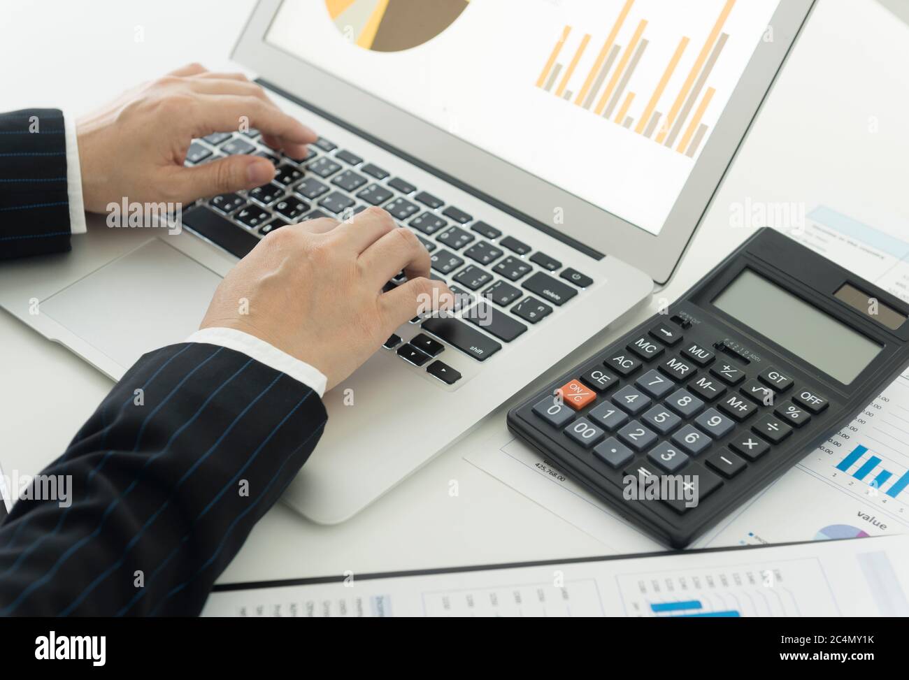 Businessman analyzing investment charts and business graphs with laptop ...