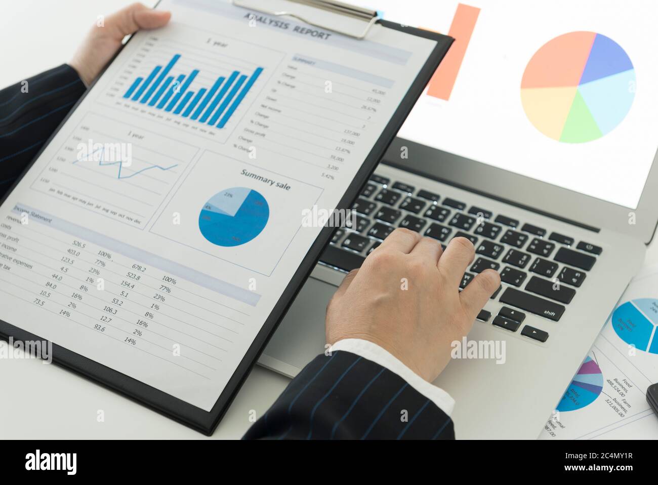 Businessman analyzing investment charts and business graphs with laptop ...