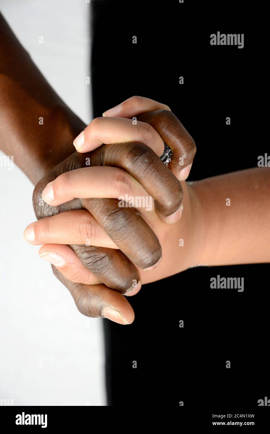 Two people of different races holding hands - concept of equality Stock ...