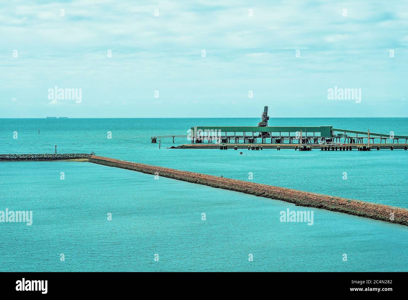 Industrial wharf with ship loading facilities beside a marina stone ...