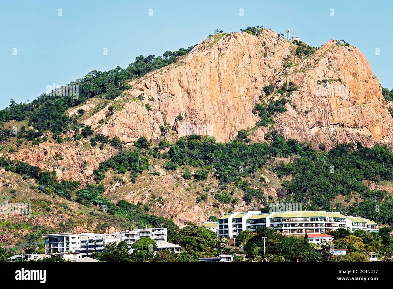 A pink granite mountain rising behind residential buildings in the ...