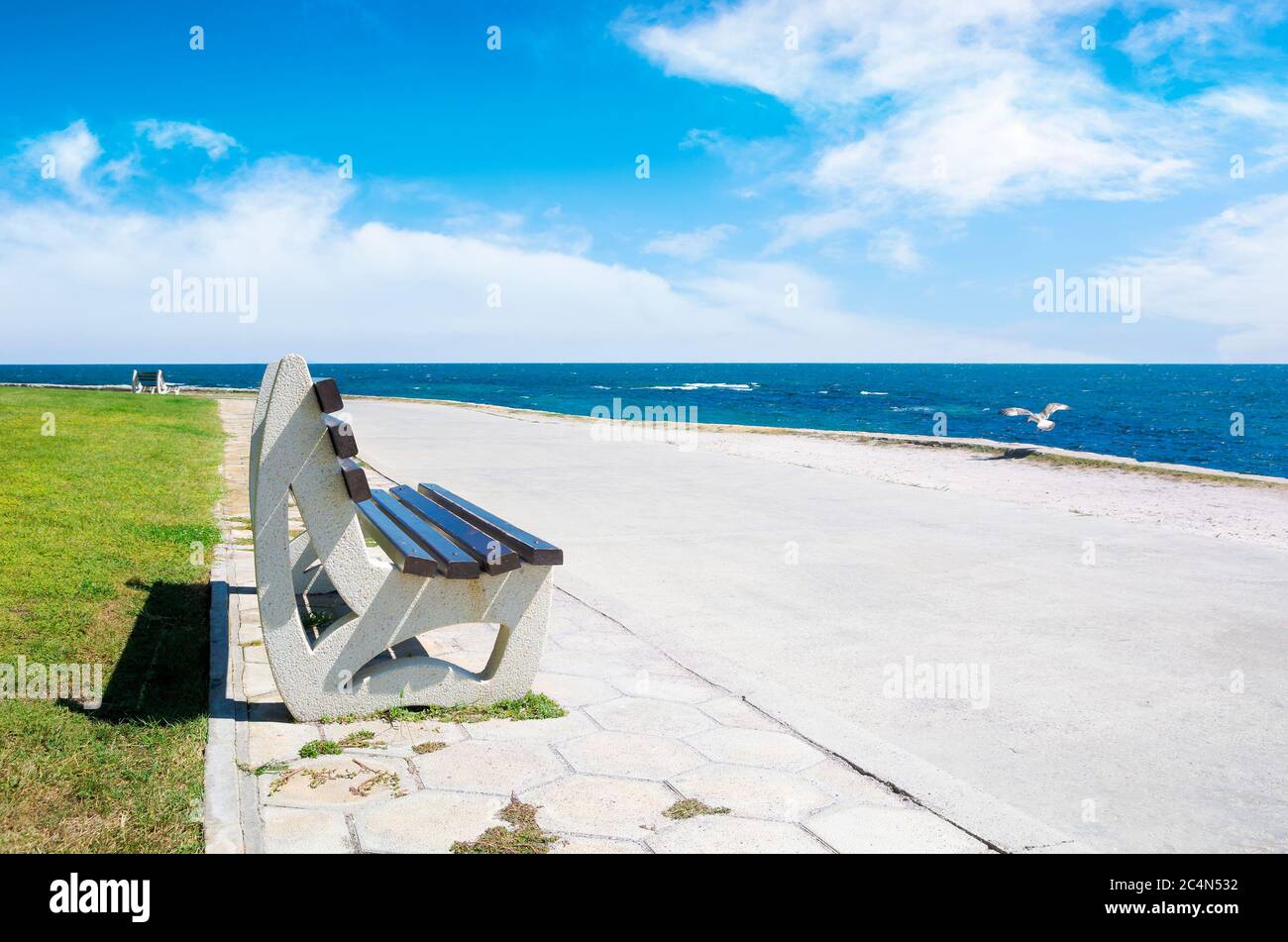 bench on the sea embankment. summer vacation and beach relax concept ...