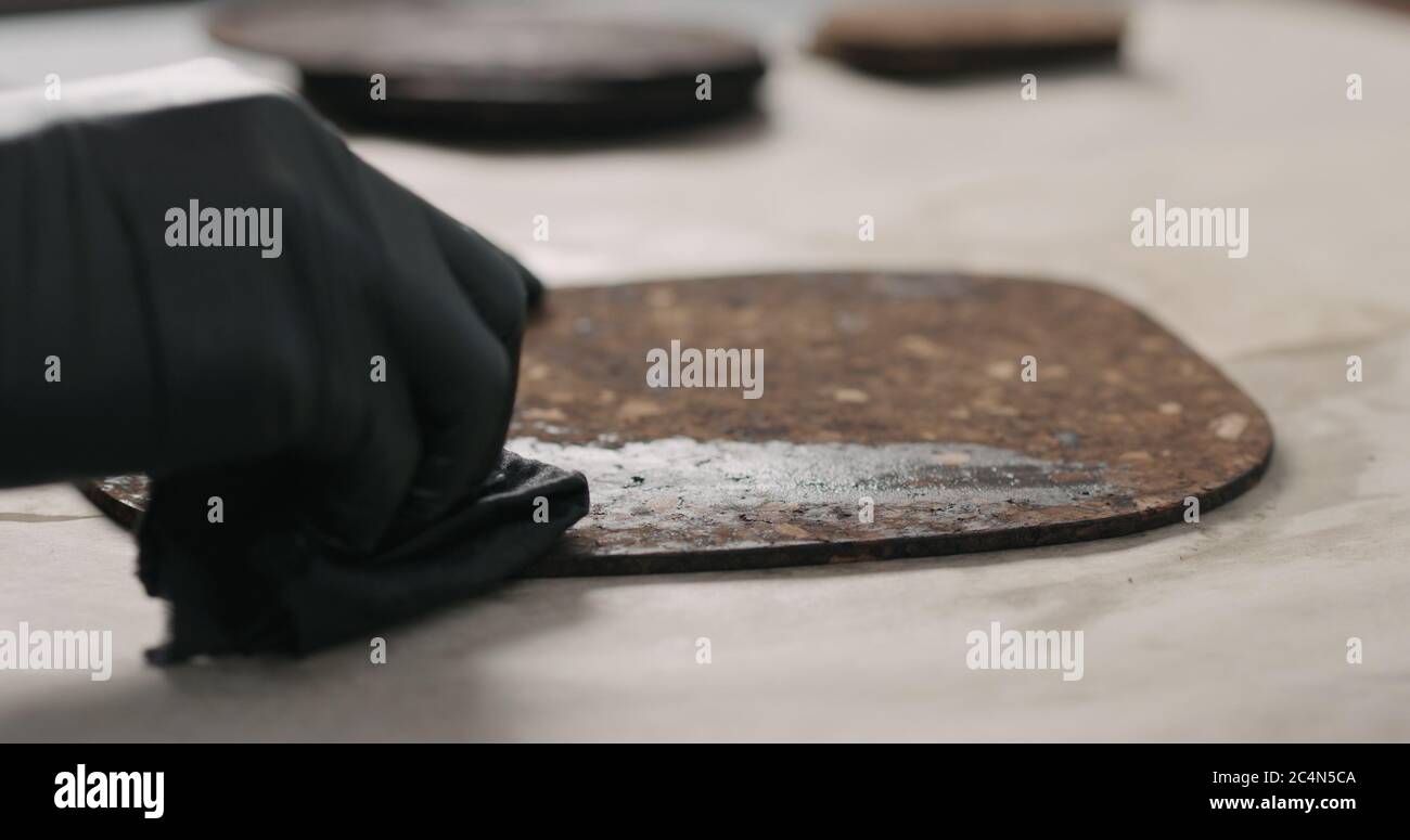 man hands applying oil finish on dark cork mat Stock Photo - Alamy